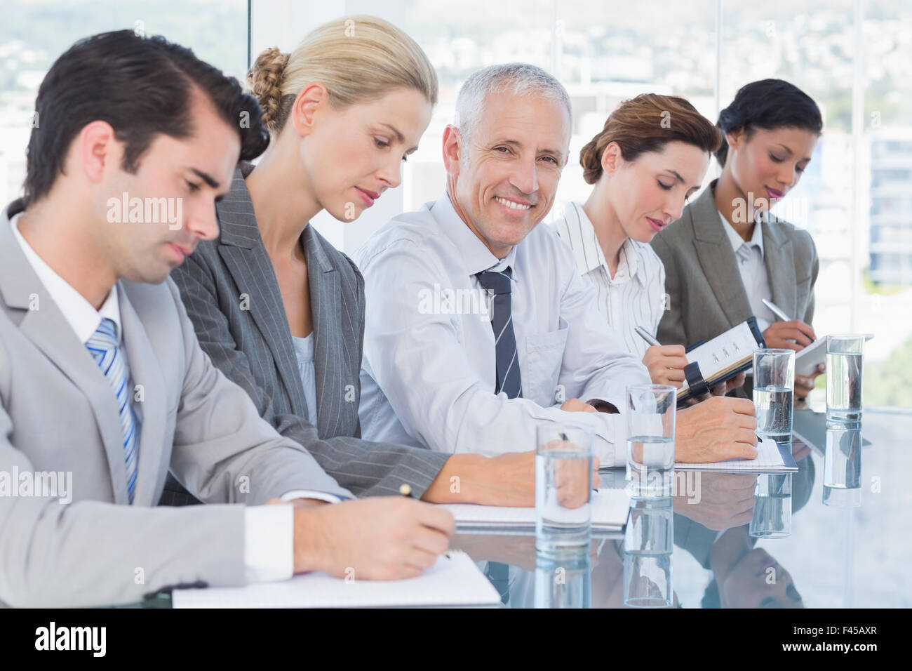 Business team taking notes during conference Stock Photo - Alamy