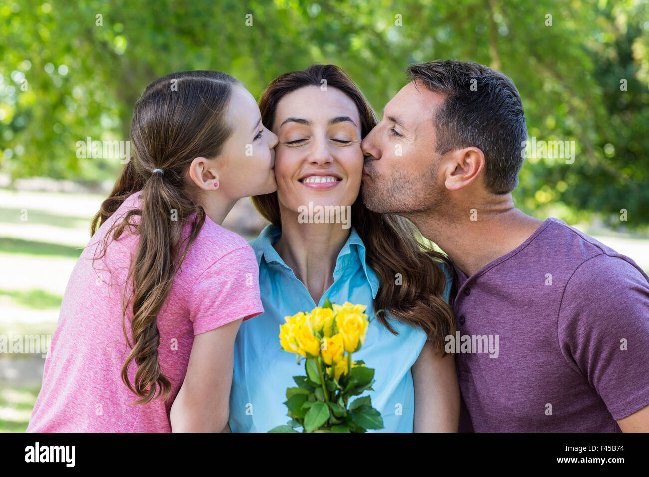 Happy family kissing at camera in the park Stock Photo - Alamy