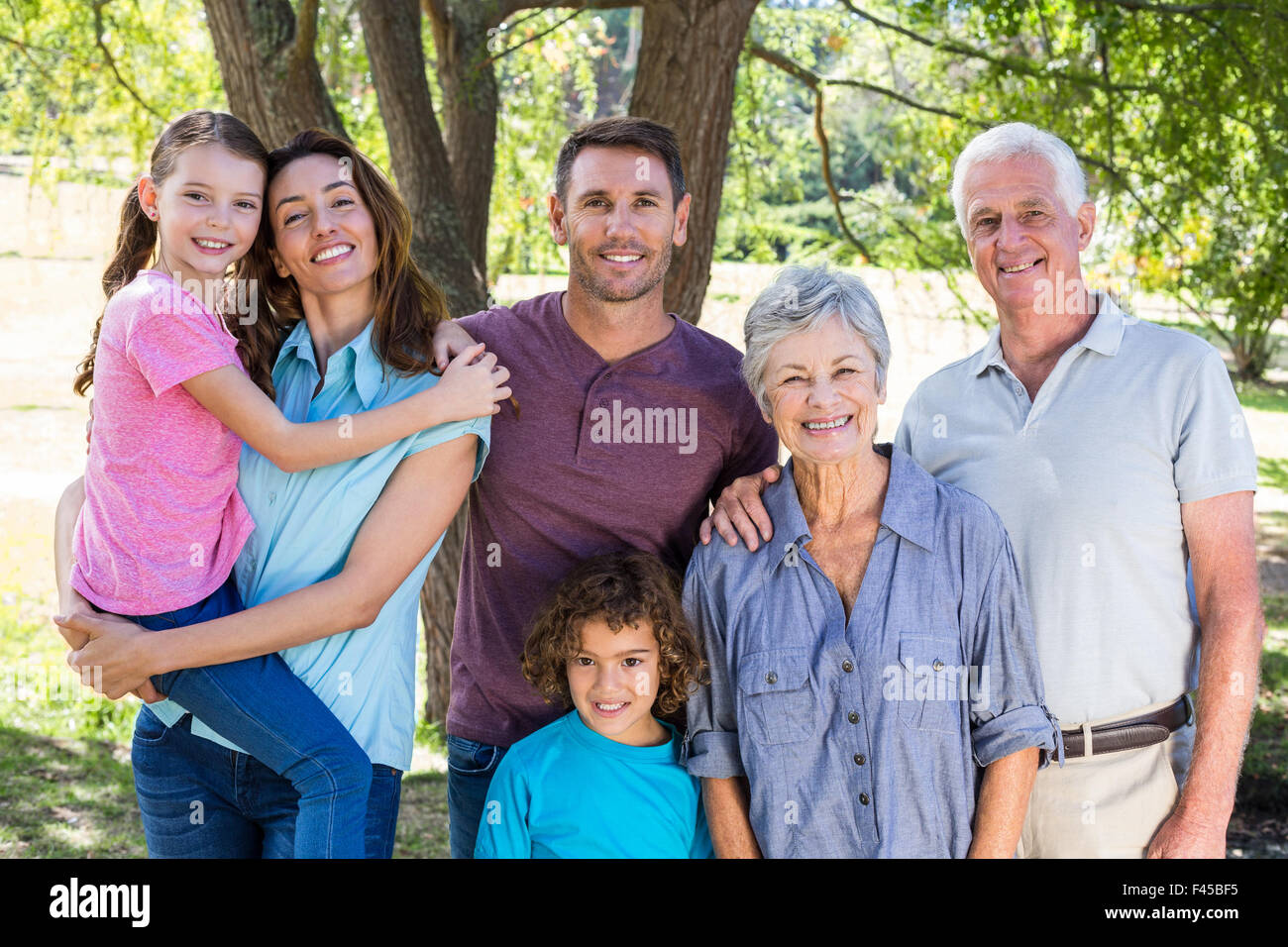 Extended family smiling in the park Stock Photo - Alamy