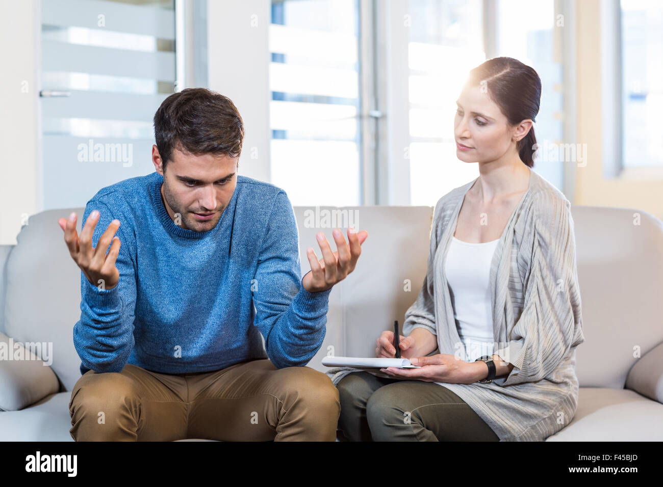 Psychologist talking with depressed man Stock Photo - Alamy
