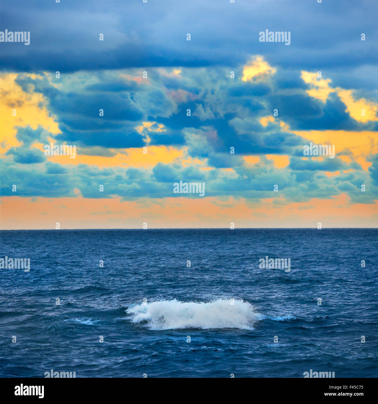 Big wave over colorful sunset Stock Photo - Alamy
