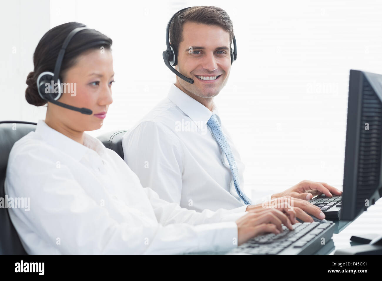 Business people with headsets using computers Stock Photo - Alamy