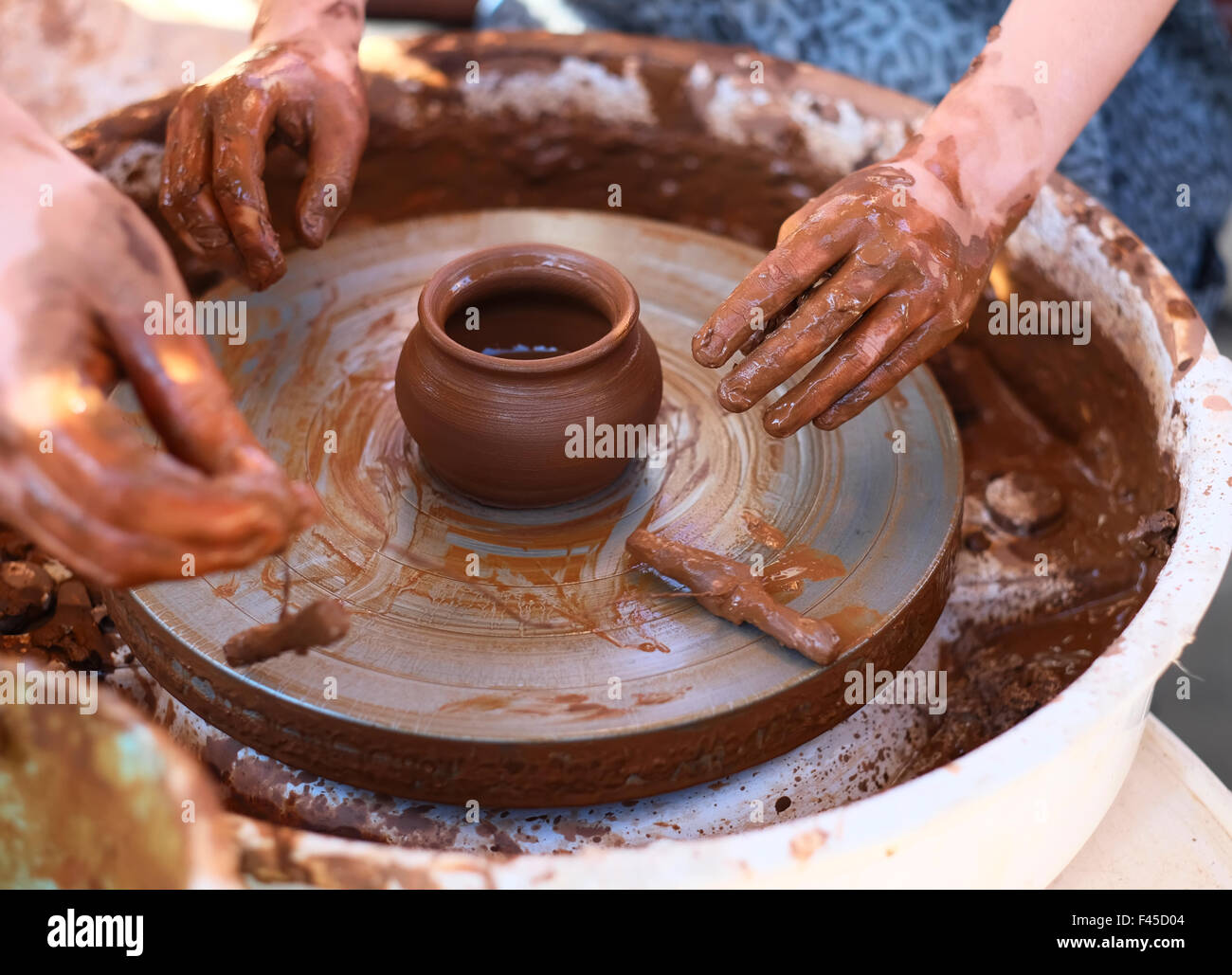 Hands working on pottery wheel Stock Photo - Alamy
