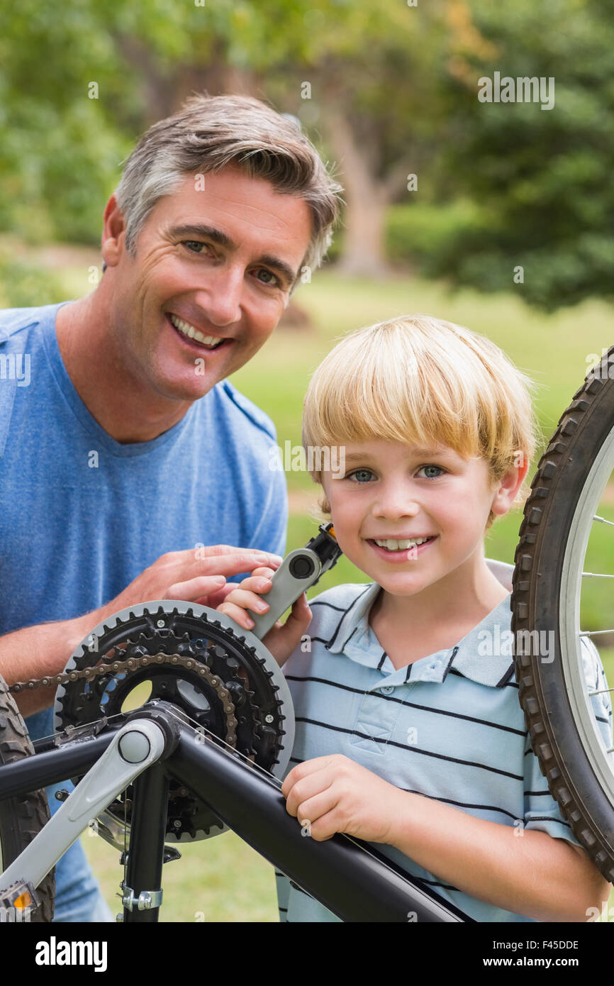 Happy father and his son fixing a bike Stock Photo - Alamy
