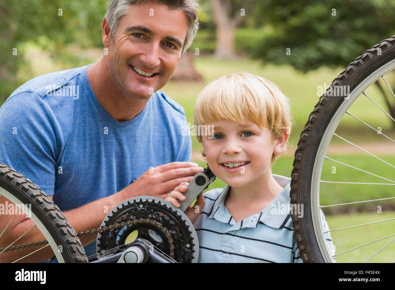 Happy father and his son fixing a bike Stock Photo - Alamy