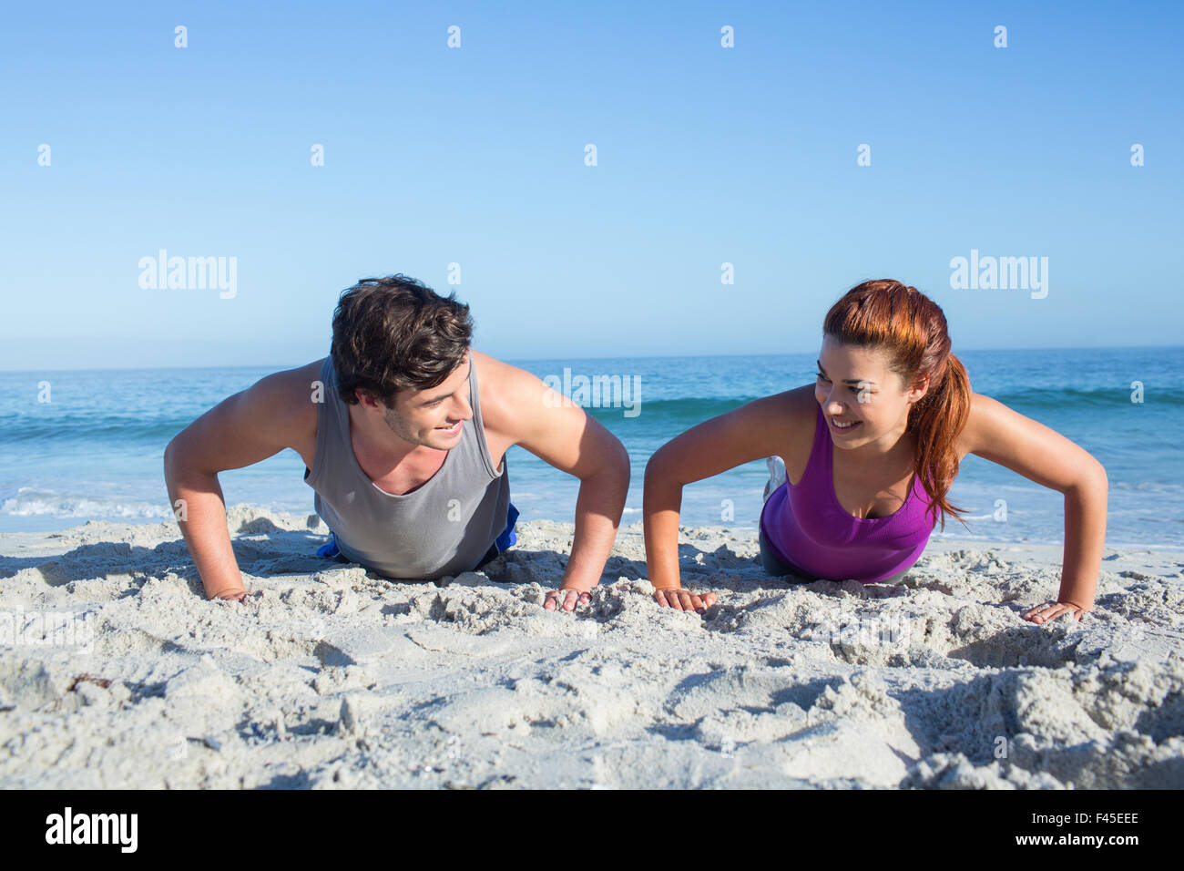 Happy couple doing push ups together Stock Photo - Alamy