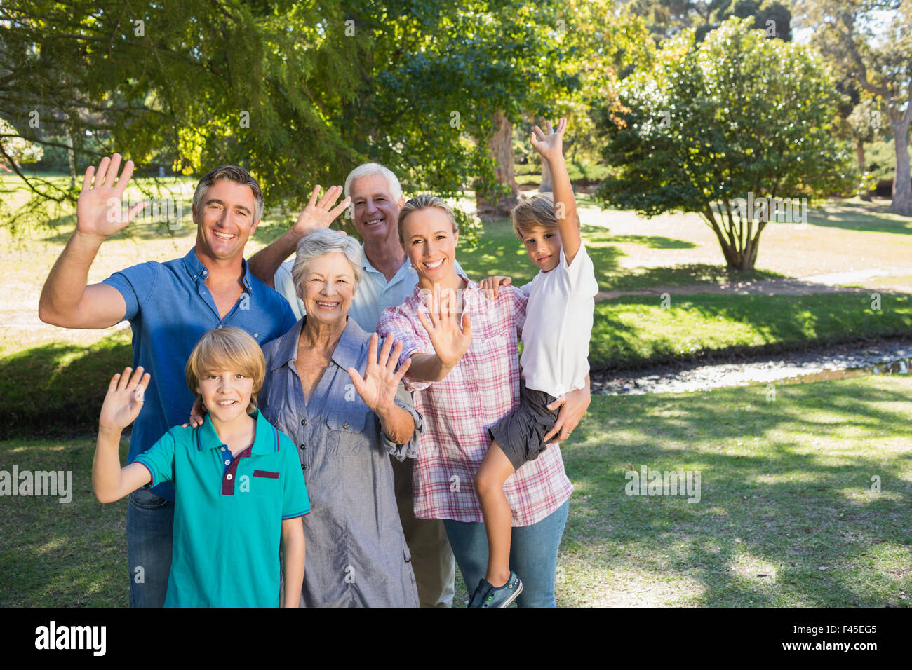 Happy family waving at camera Stock Photo - Alamy