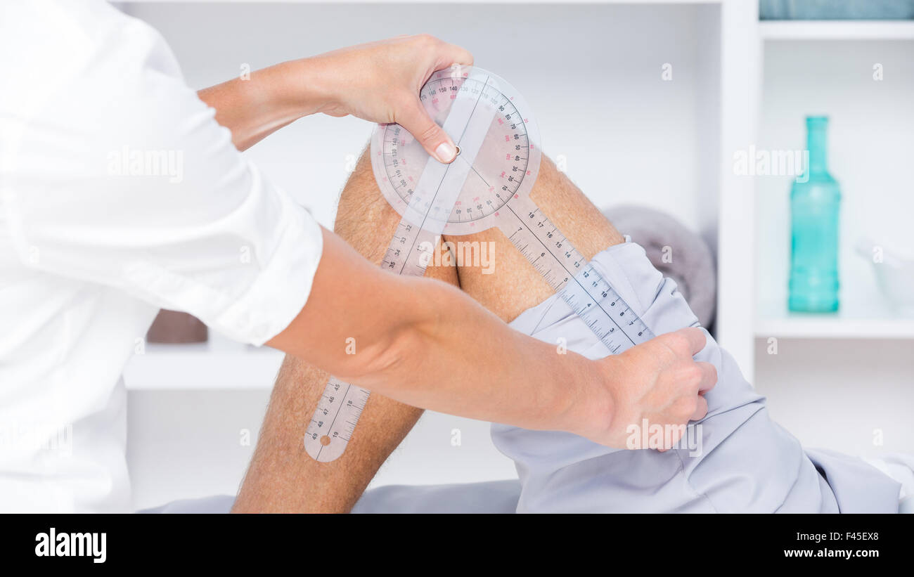 Doctor examining man leg with tool Stock Photo - Alamy