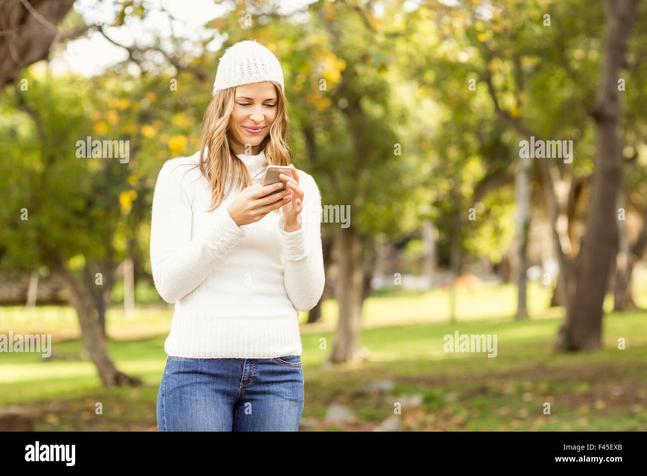 Smiling pretty woman texting with her smartphone Stock Photo - Alamy