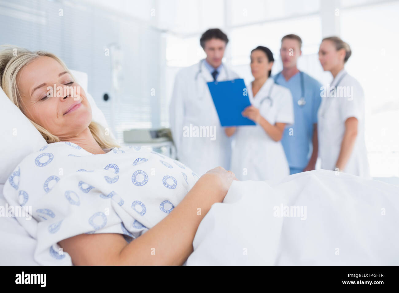 Sleeping patient with doctors behind Stock Photo - Alamy