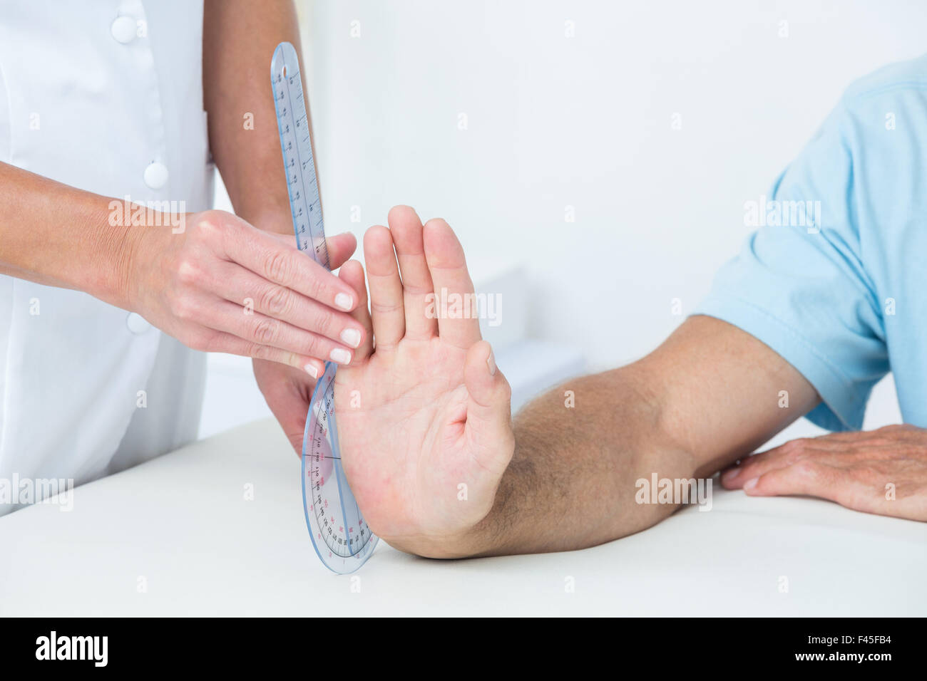 Doctor measuring wrist with goniometer Stock Photo - Alamy