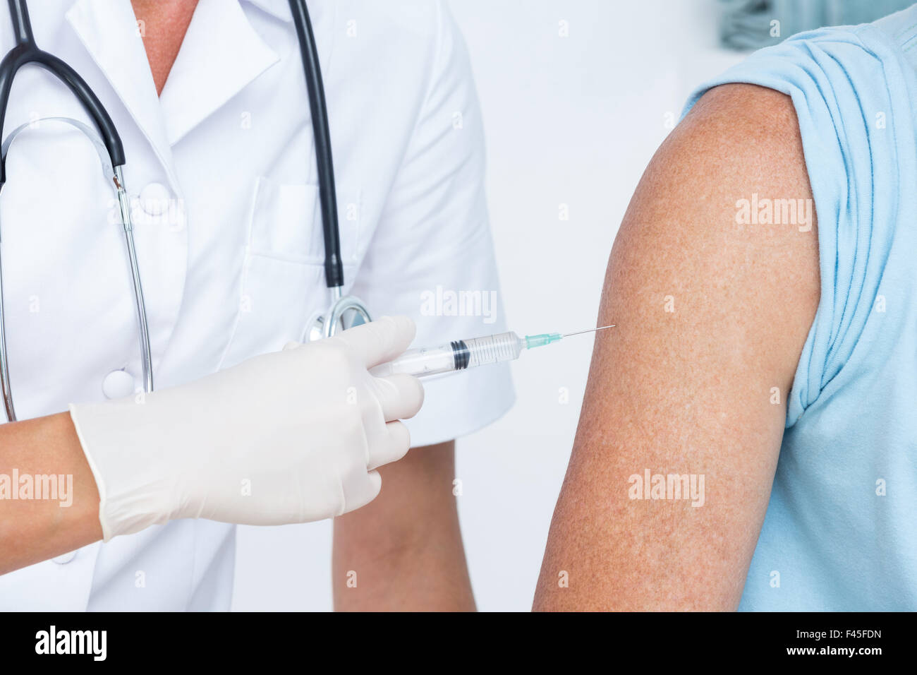 Doctor doing an injection to her patient Stock Photo - Alamy