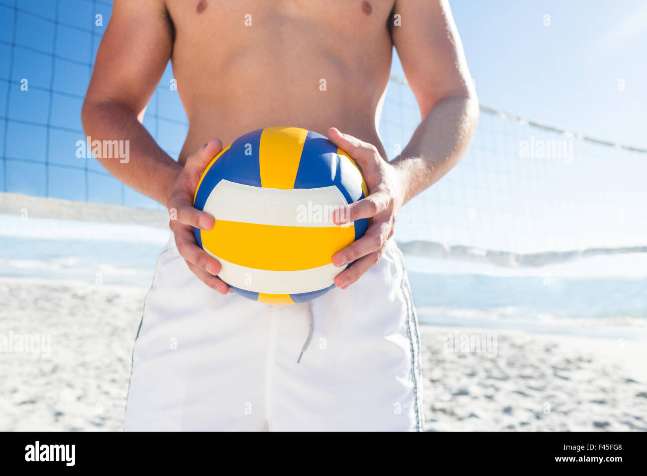 Handsome man holding volleyball Stock Photo - Alamy
