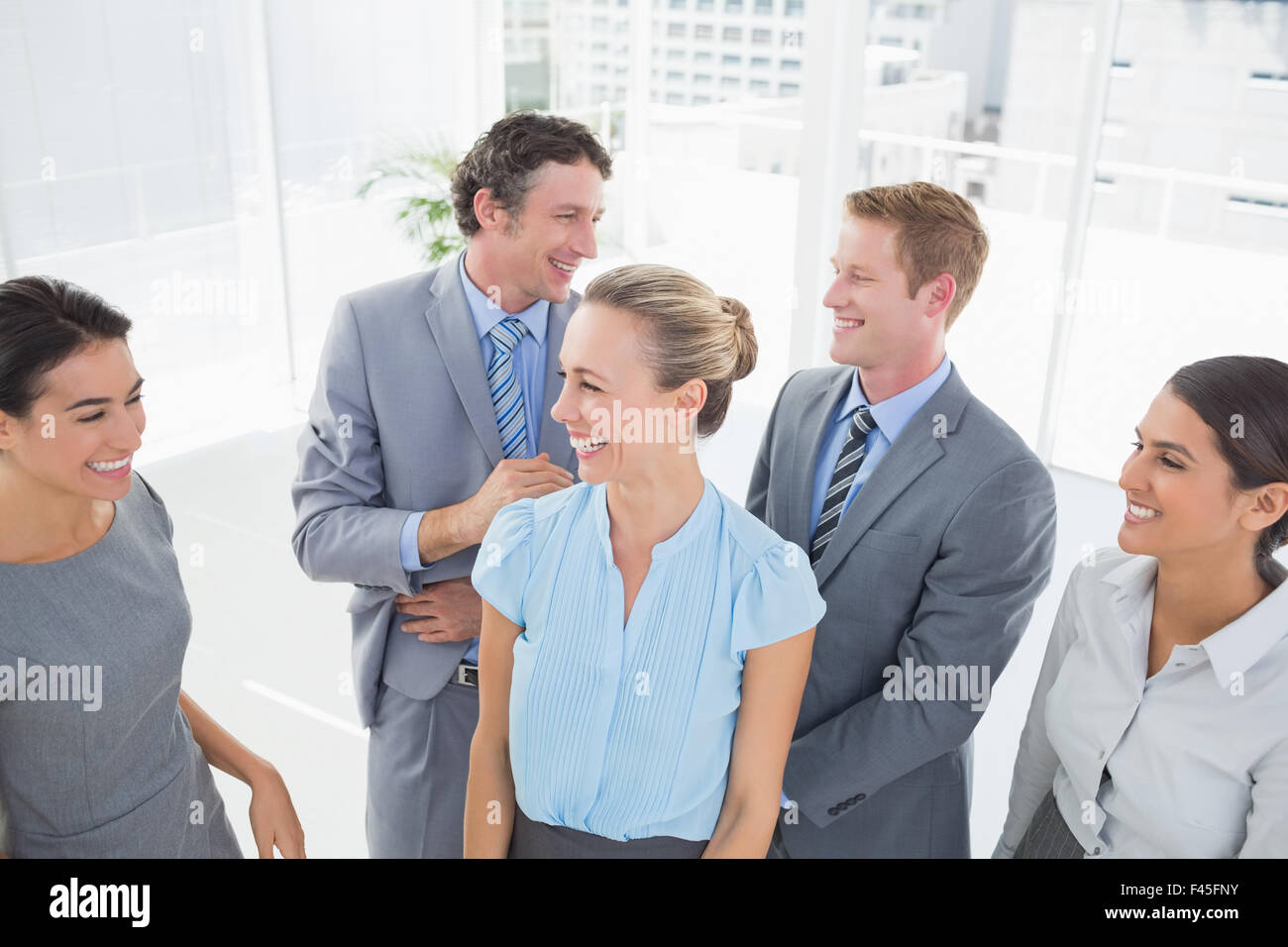 Happy business team smiling at each other Stock Photo - Alamy