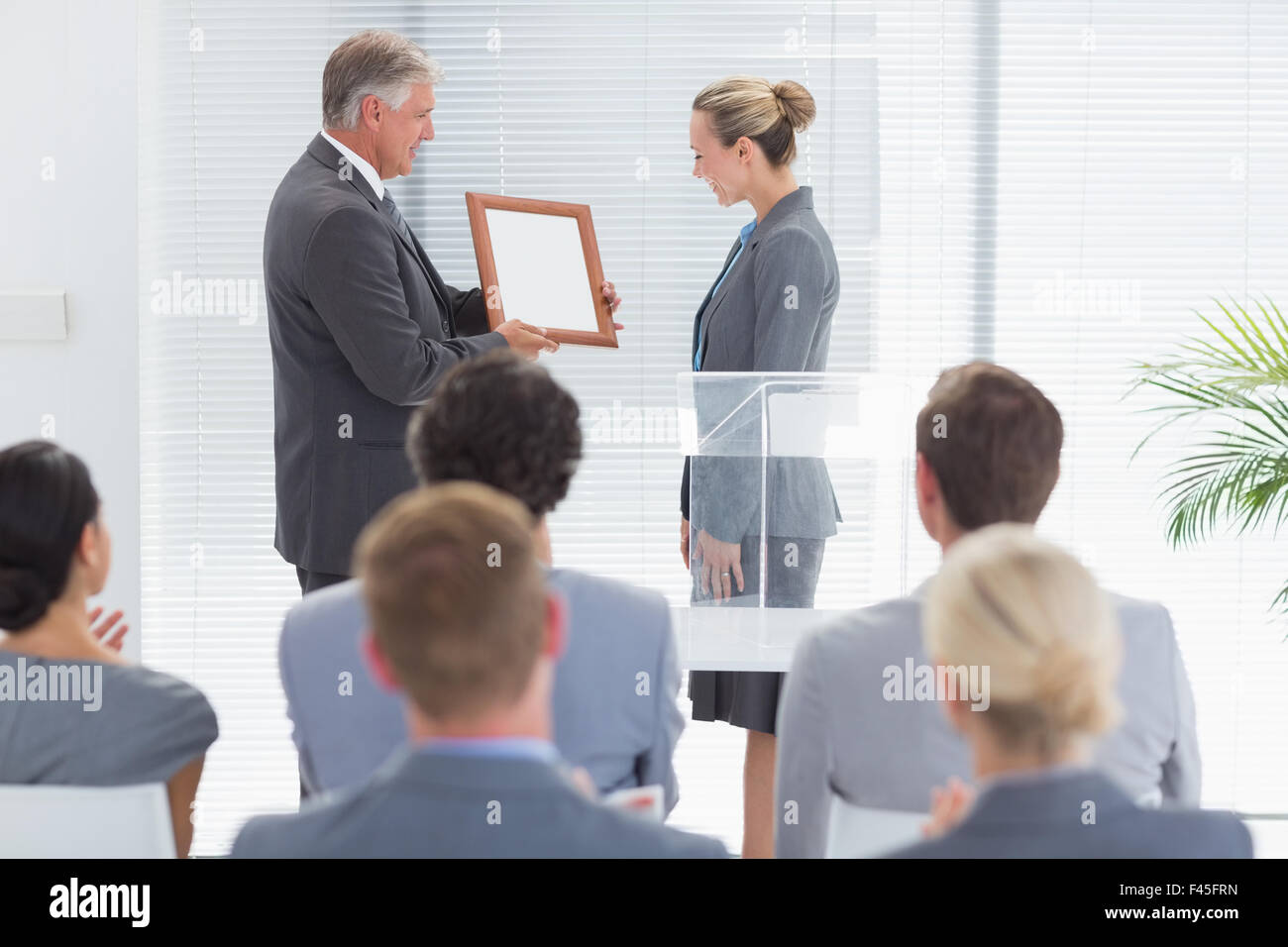 Pretty businesswoman receiving prize Stock Photo - Alamy