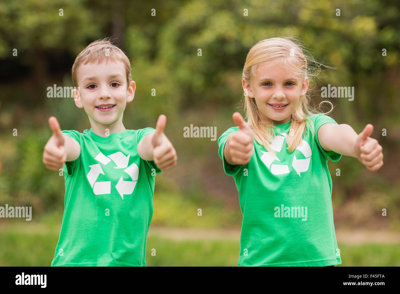 Happy siblings in green with thumbs up Stock Photo - Alamy