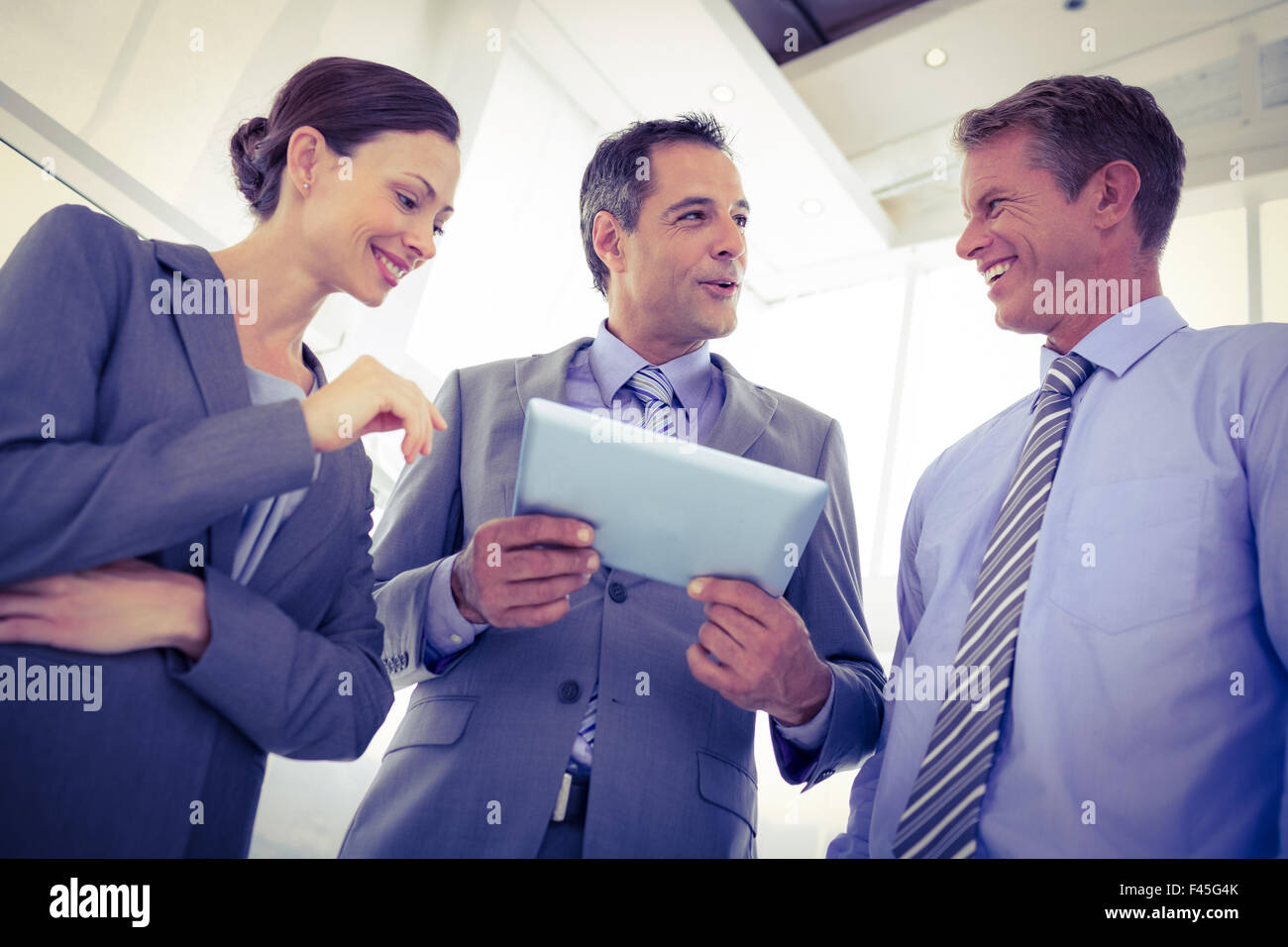 Business team using tablet together Stock Photo - Alamy