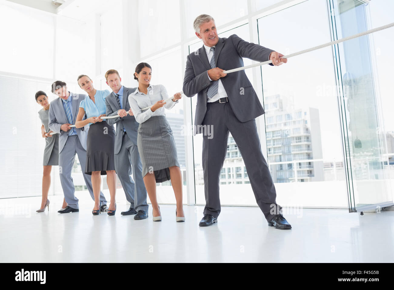 Business team pulling the rope Stock Photo - Alamy