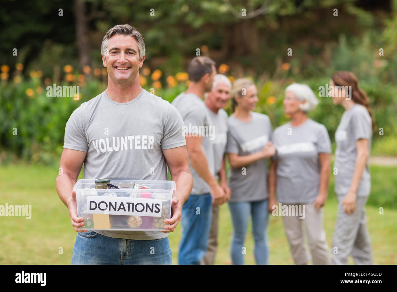Happy man holding donations boxes Stock Photo - Alamy