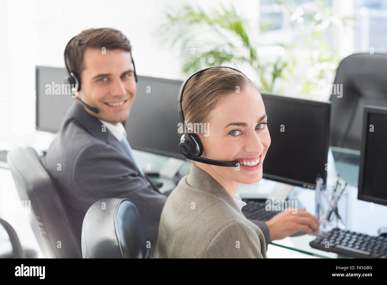 Business people with headsets using computers Stock Photo - Alamy
