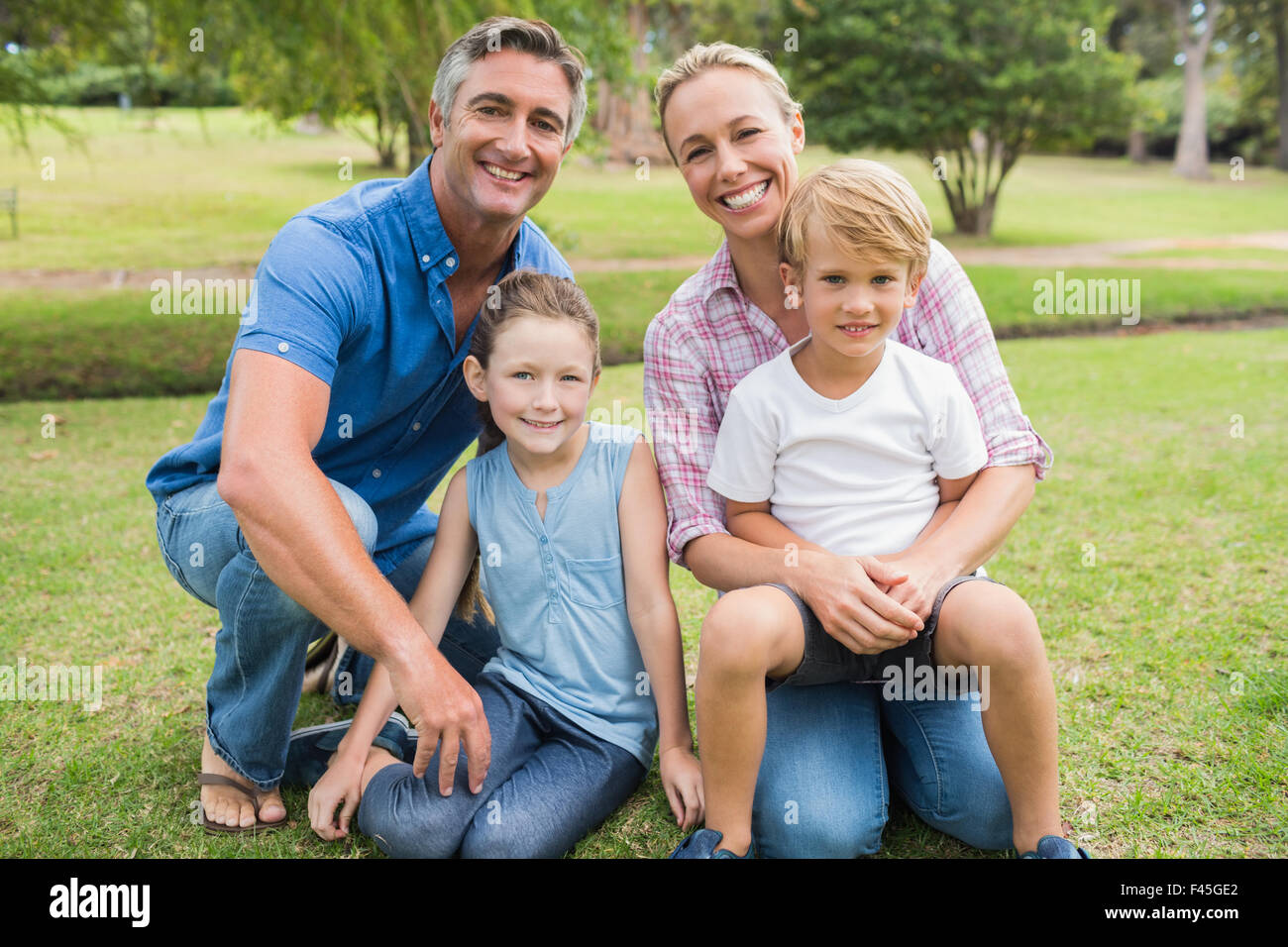 Happy family smiling at the camera Stock Photo - Alamy
