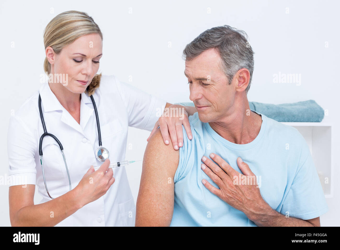 Doctor doing an injection to her patient Stock Photo - Alamy