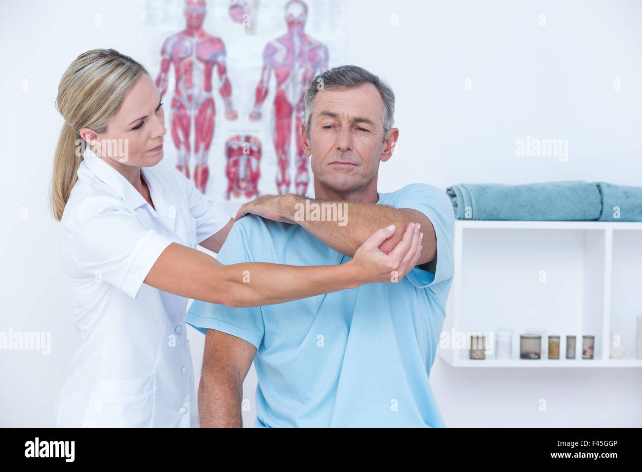 Doctor stretching a man arm Stock Photo - Alamy