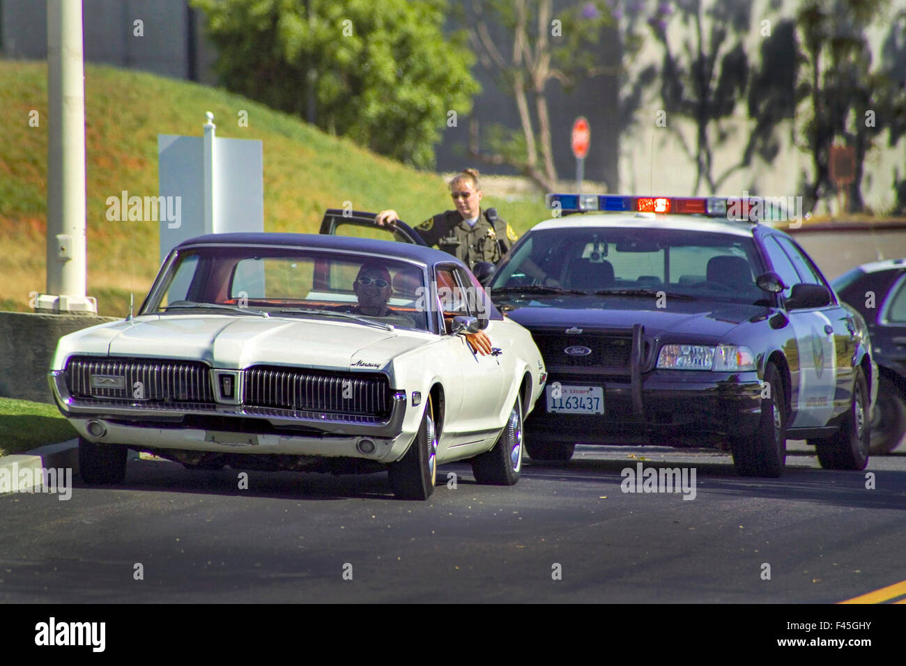A woman police officer waits for backup before proceeding with a ...