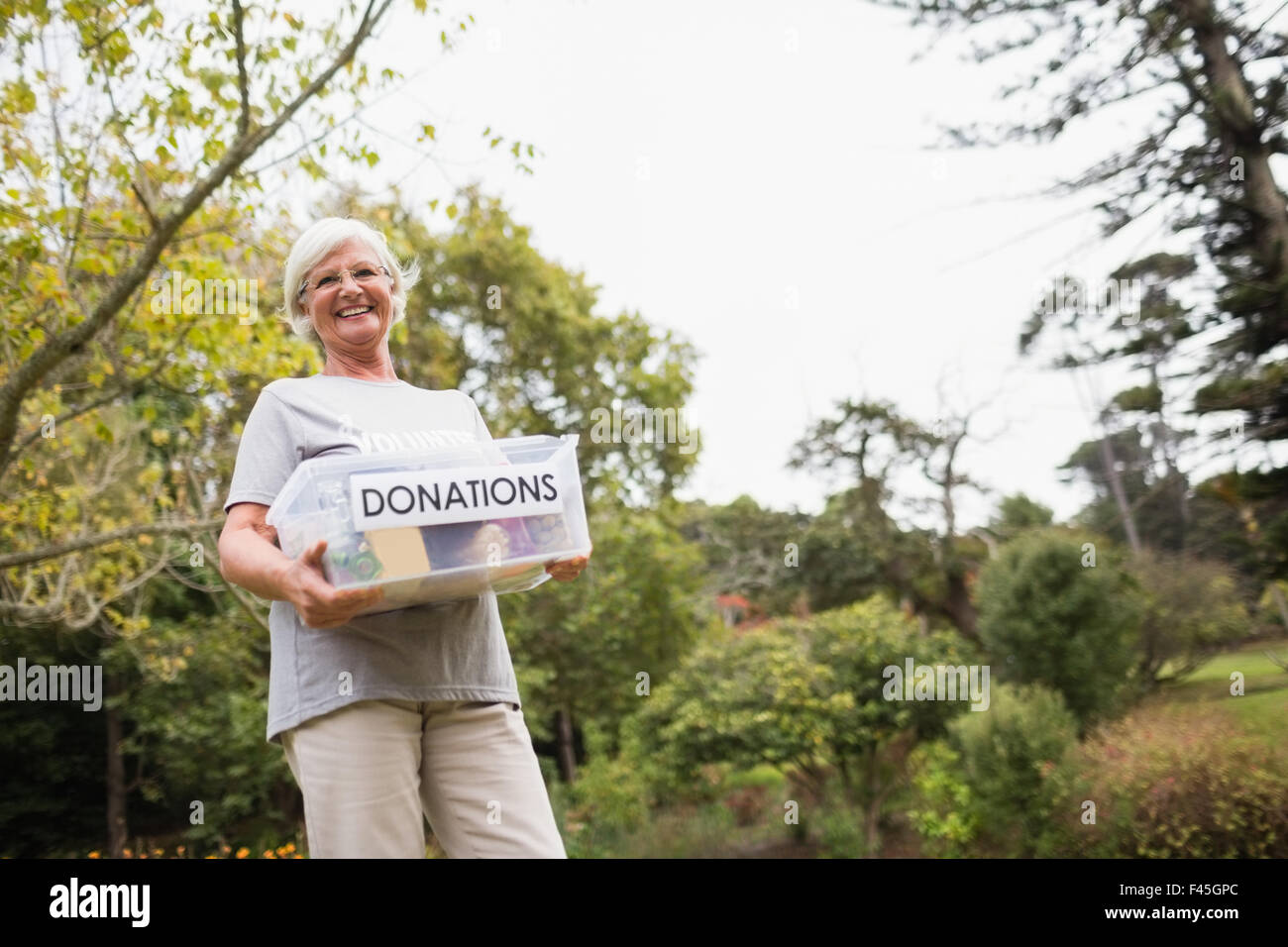 Happy grandmother holding donation box Stock Photo - Alamy
