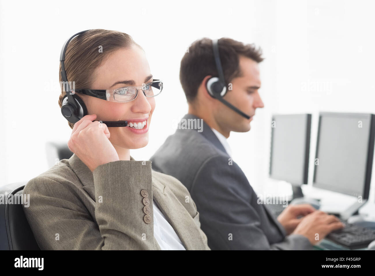Business people with headsets using computers Stock Photo - Alamy