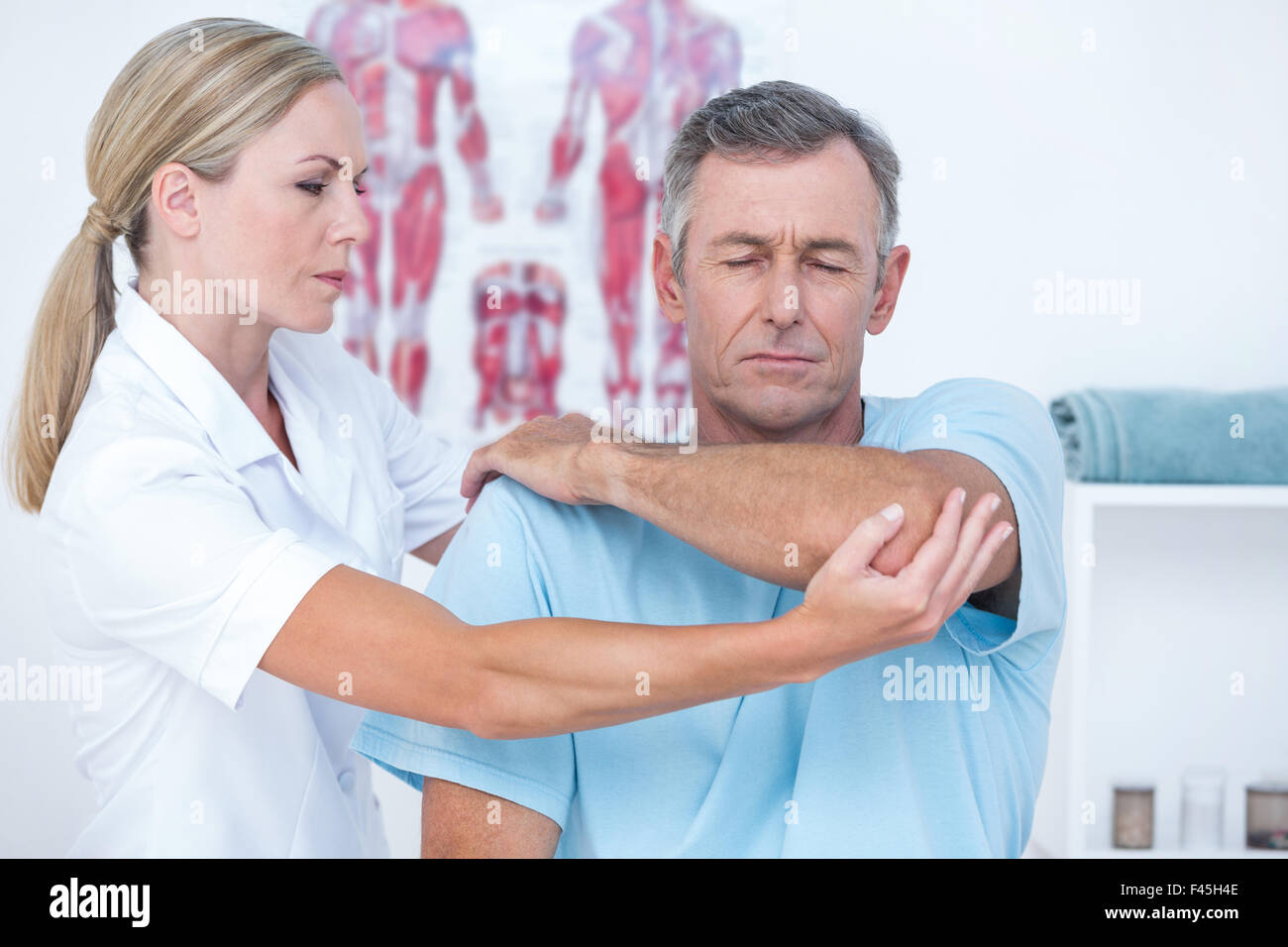 Doctor stretching a man arm Stock Photo - Alamy