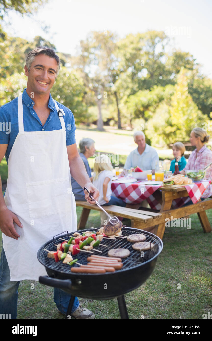 Happy man doing barbecue for his family Stock Photo - Alamy