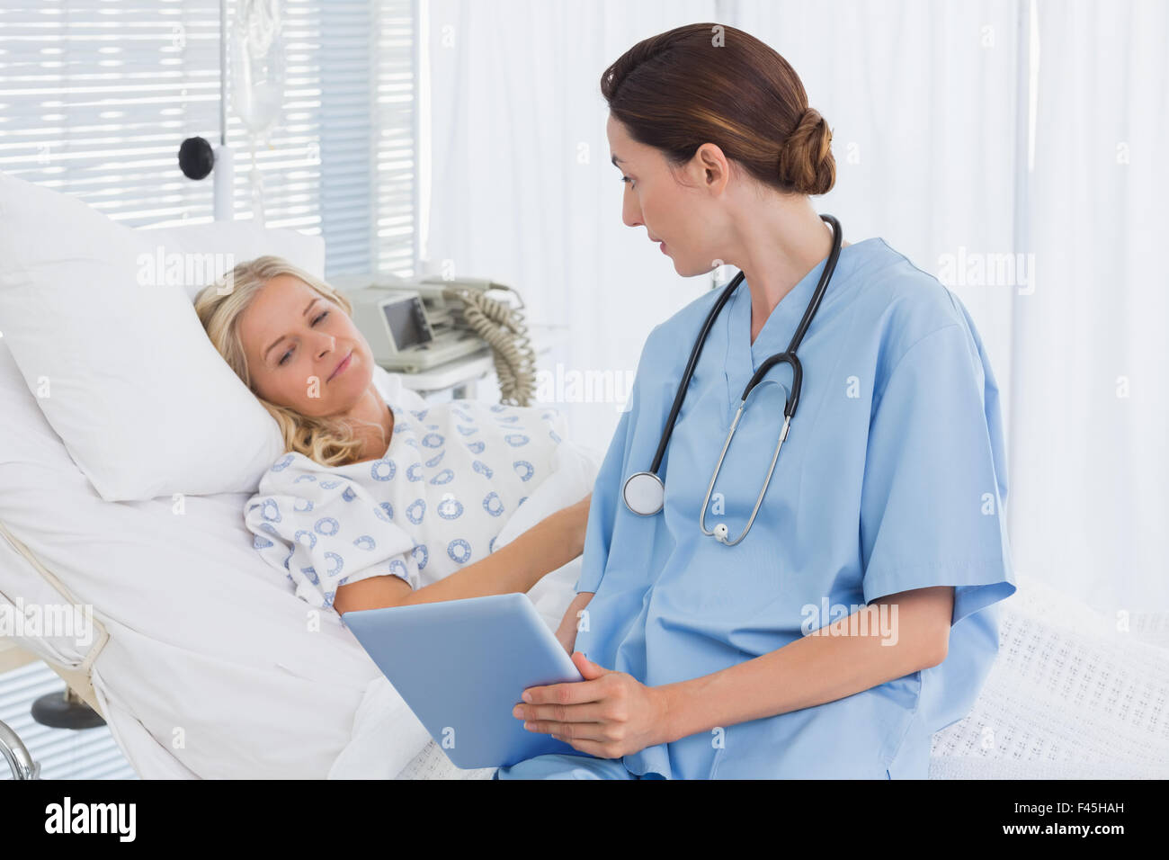 Doctor showing tablet to her patient Stock Photo - Alamy