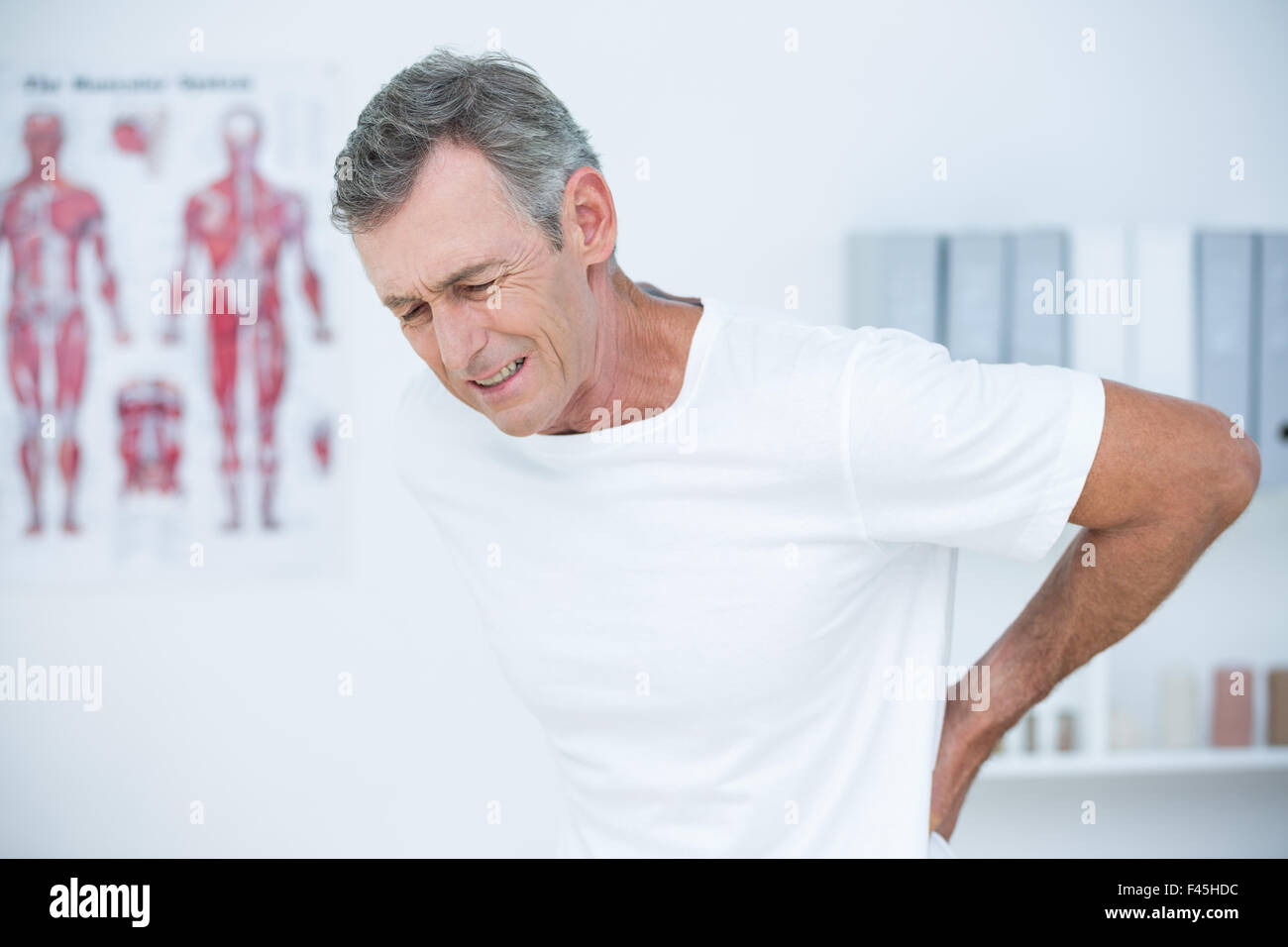 Suffering patient touching his back Stock Photo - Alamy