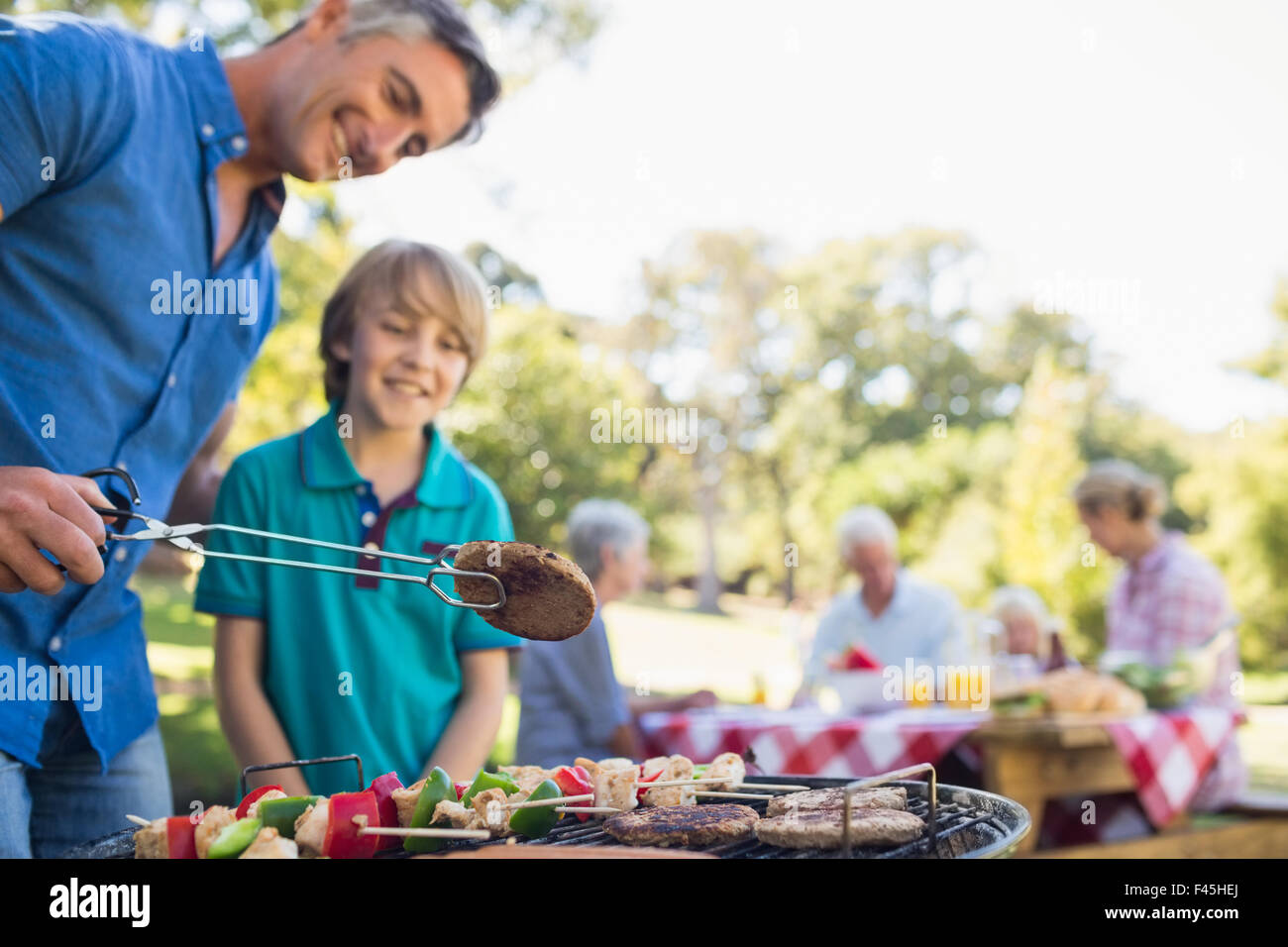 Happy father doing barbecue with his son Stock Photo - Alamy