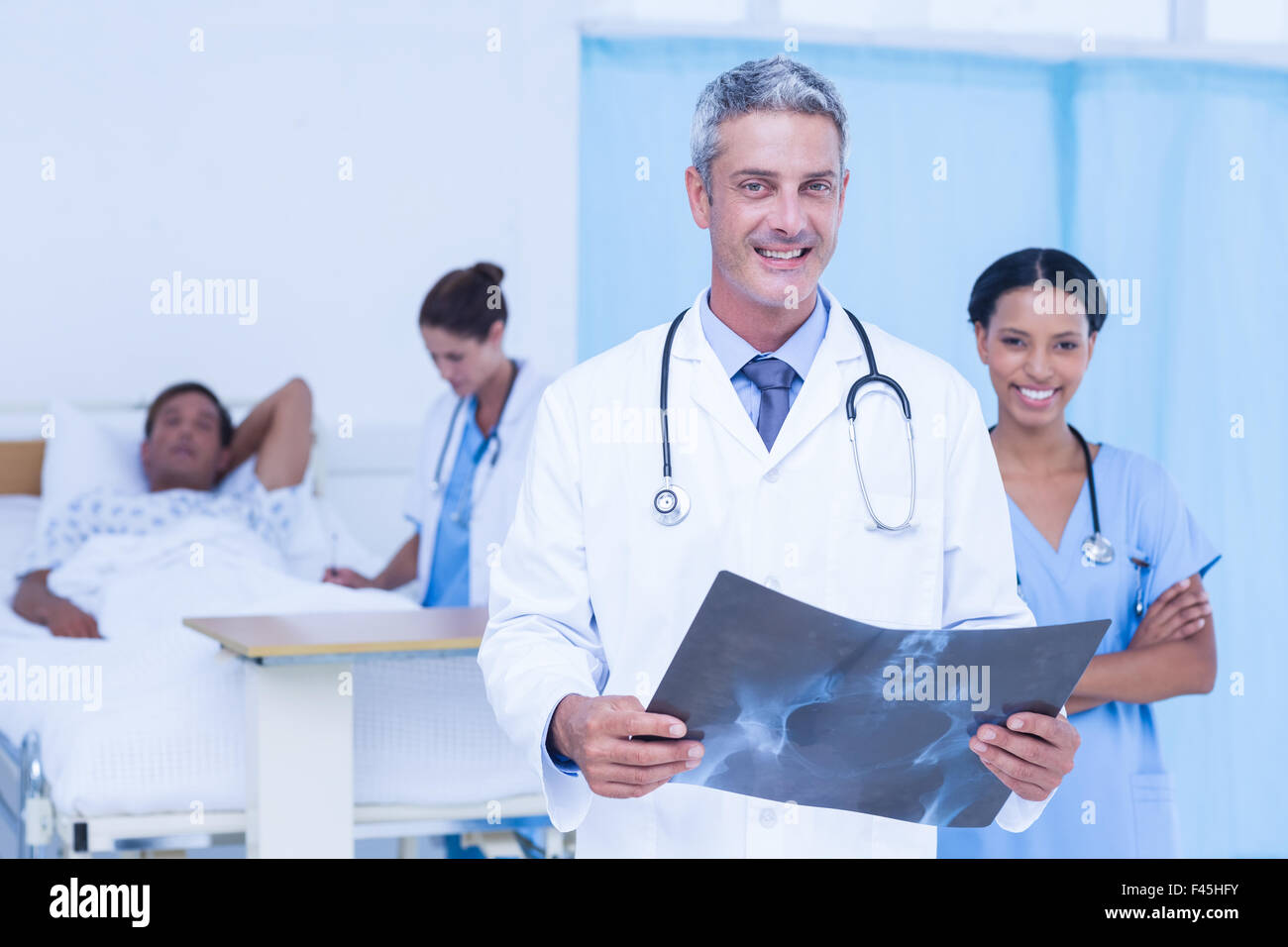 Doctor with colleague and patient behind Stock Photo - Alamy