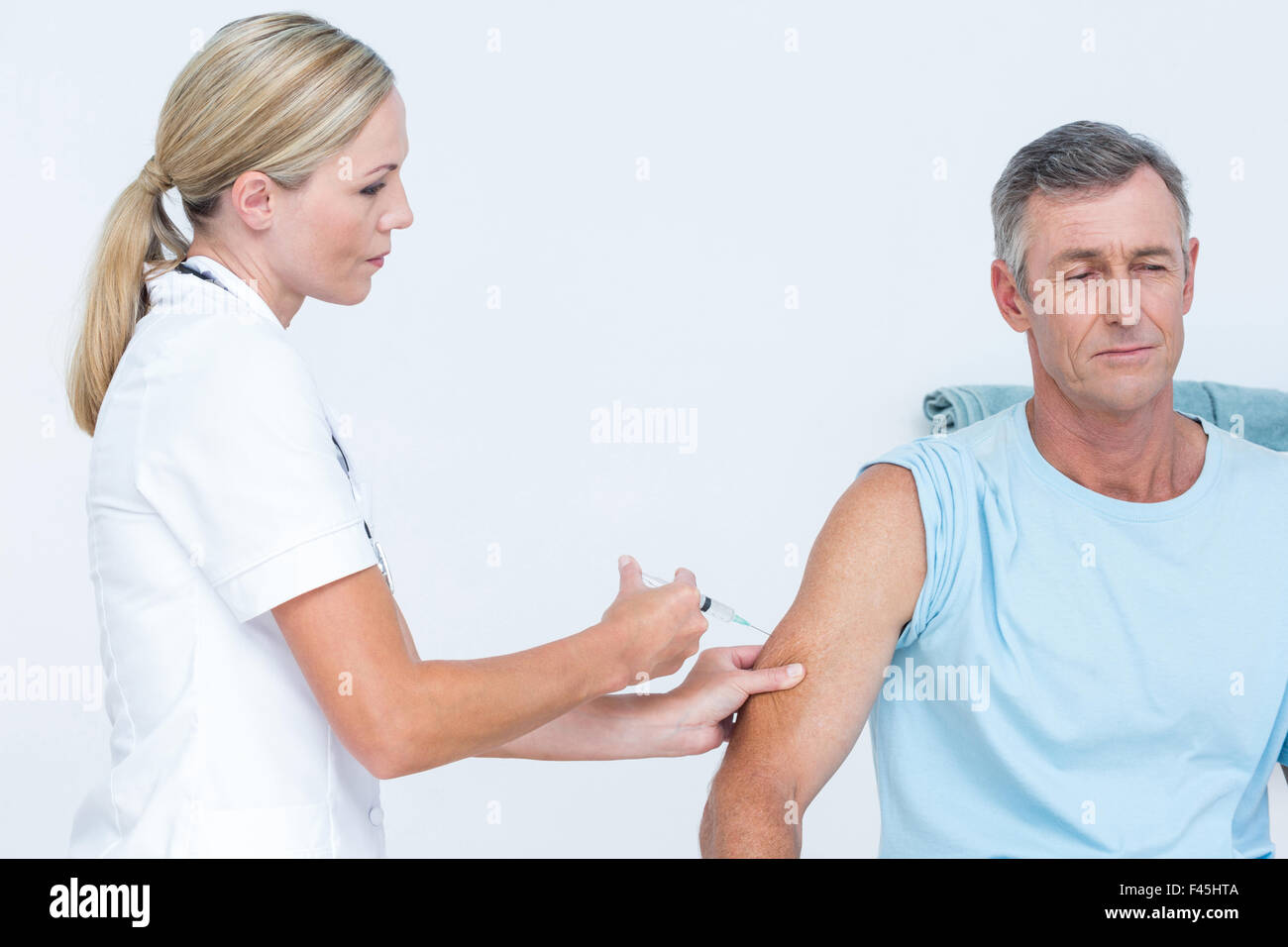Doctor doing an injection to her patient Stock Photo - Alamy