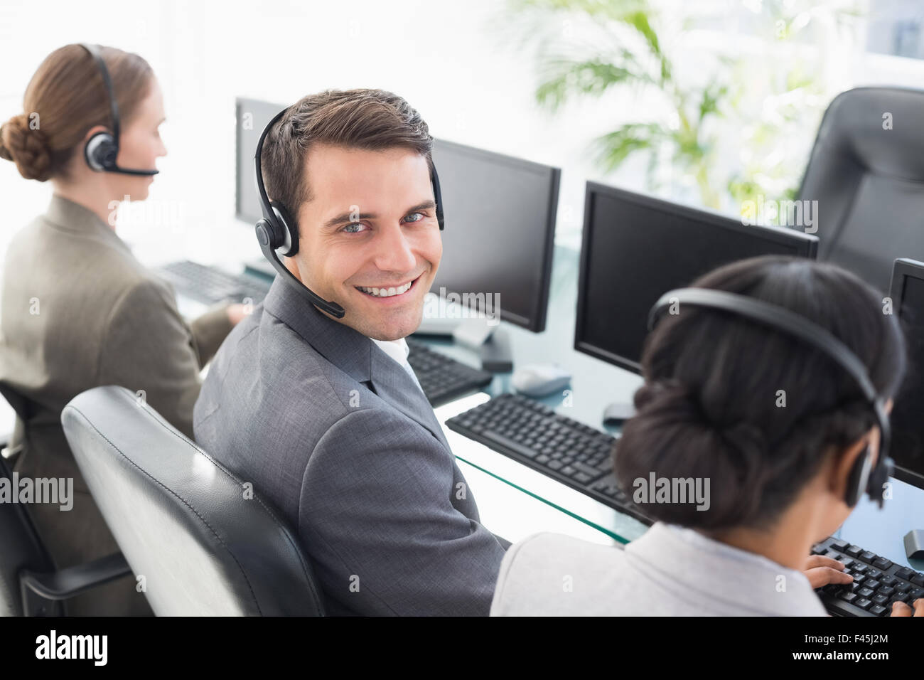 Business people with headsets using computers Stock Photo - Alamy