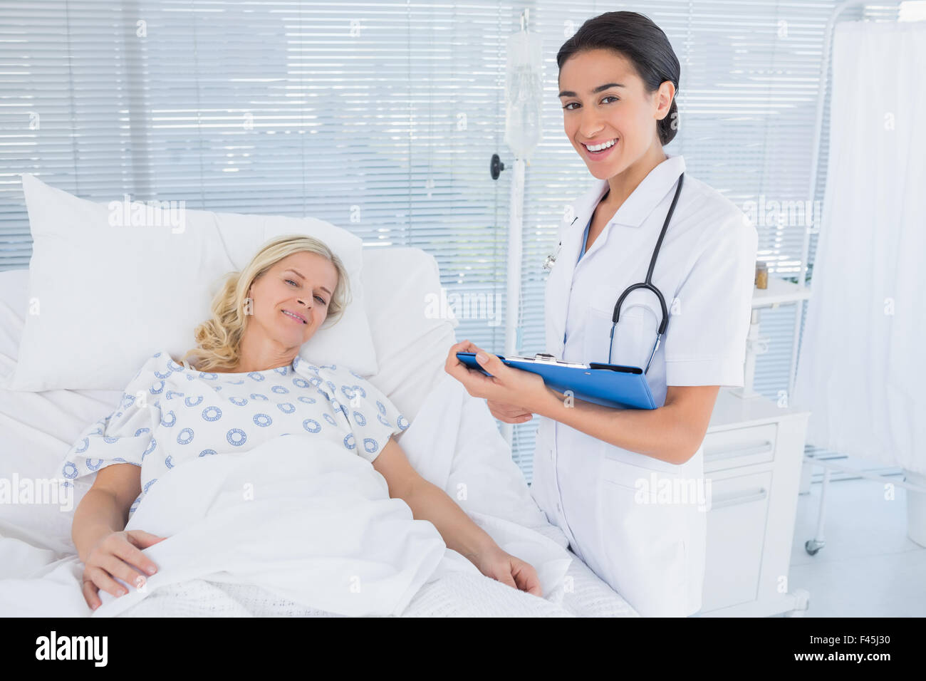 Smiling doctor standing next to her patient Stock Photo - Alamy