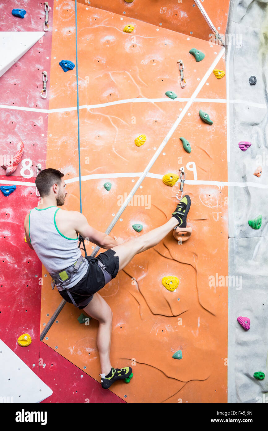 Fit man rock climbing indoors Stock Photo - Alamy