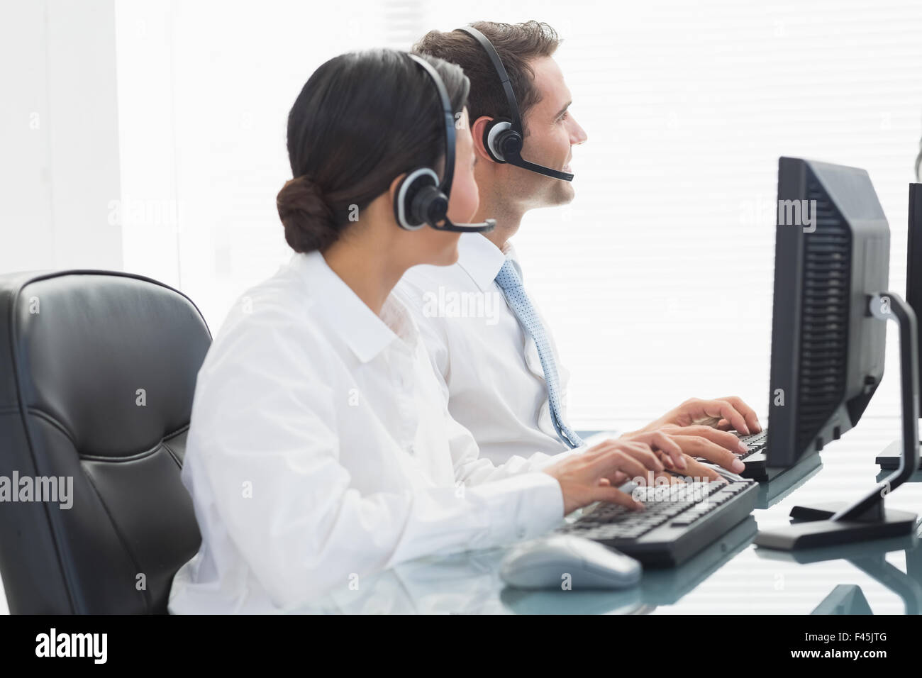 Business people with headsets using computers Stock Photo - Alamy