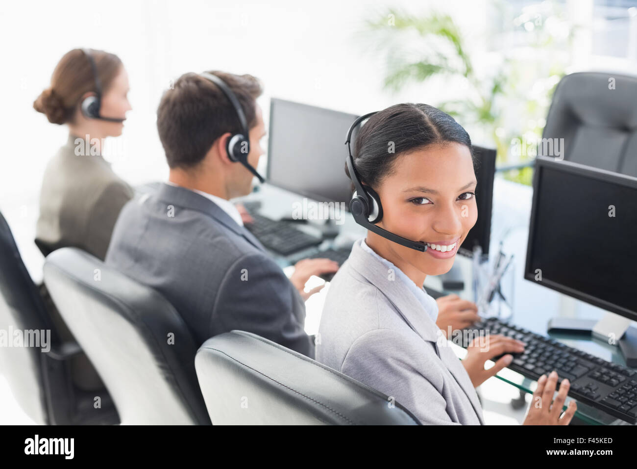 Business people with headsets using computers Stock Photo - Alamy