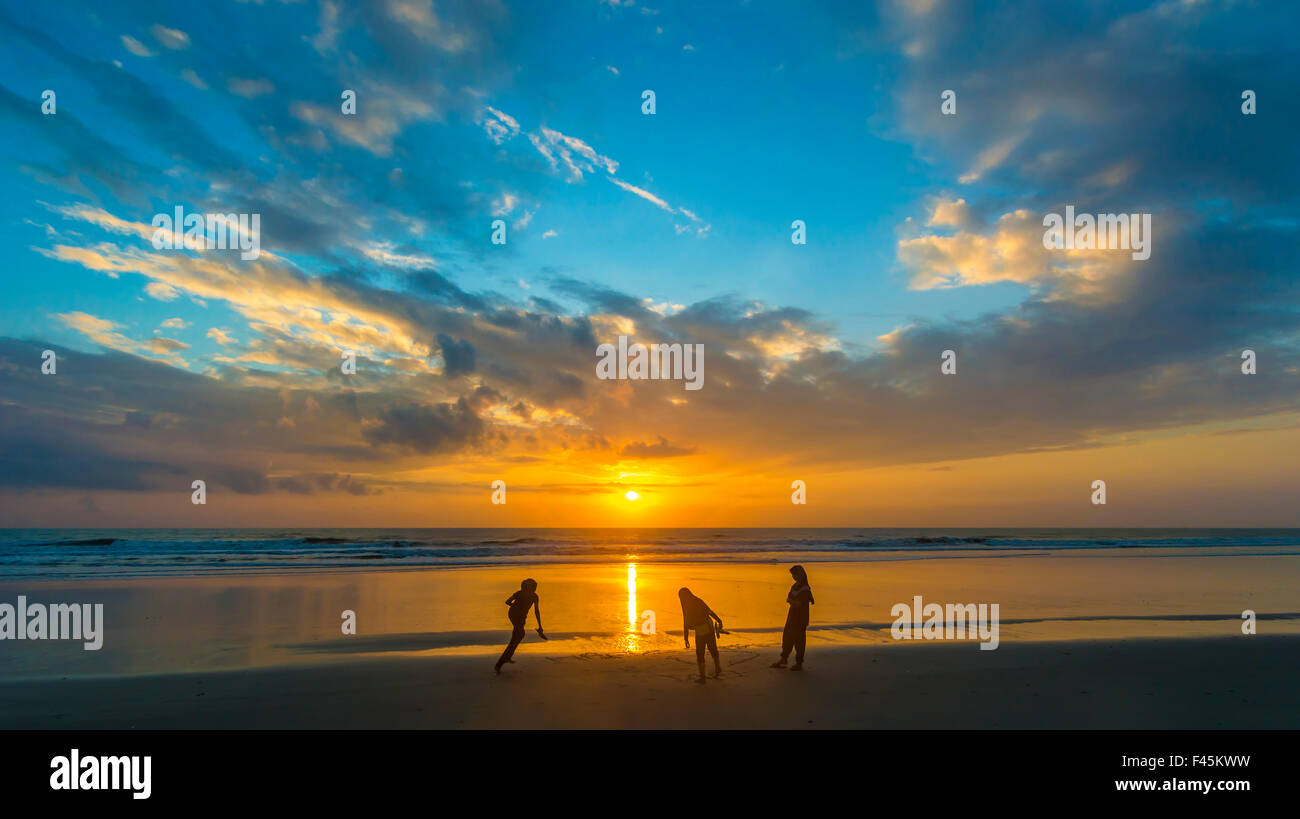 Sunrise with children playing silhouette foreground Stock Photo - Alamy