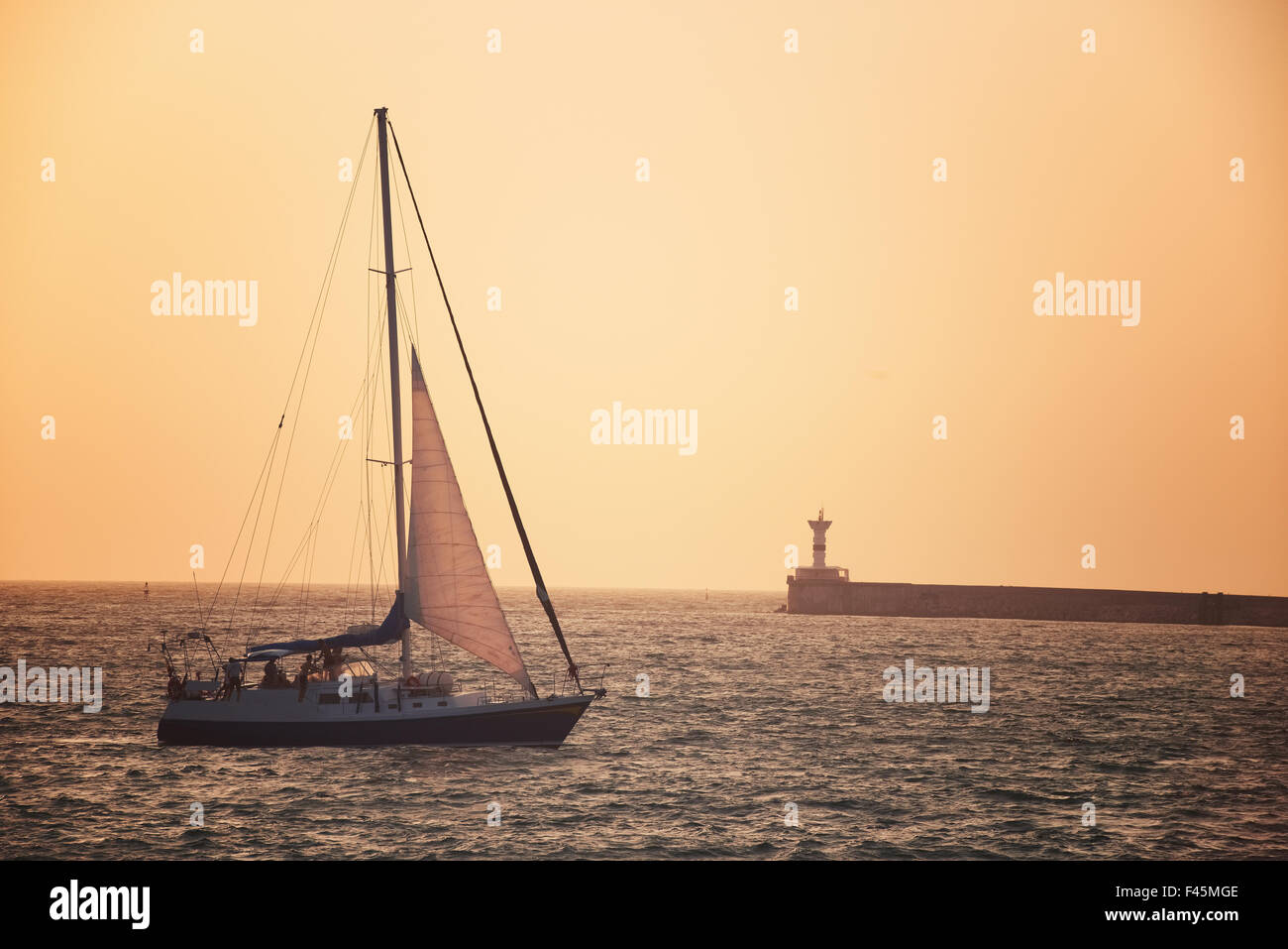 Sail boat against sea sunset Stock Photo - Alamy