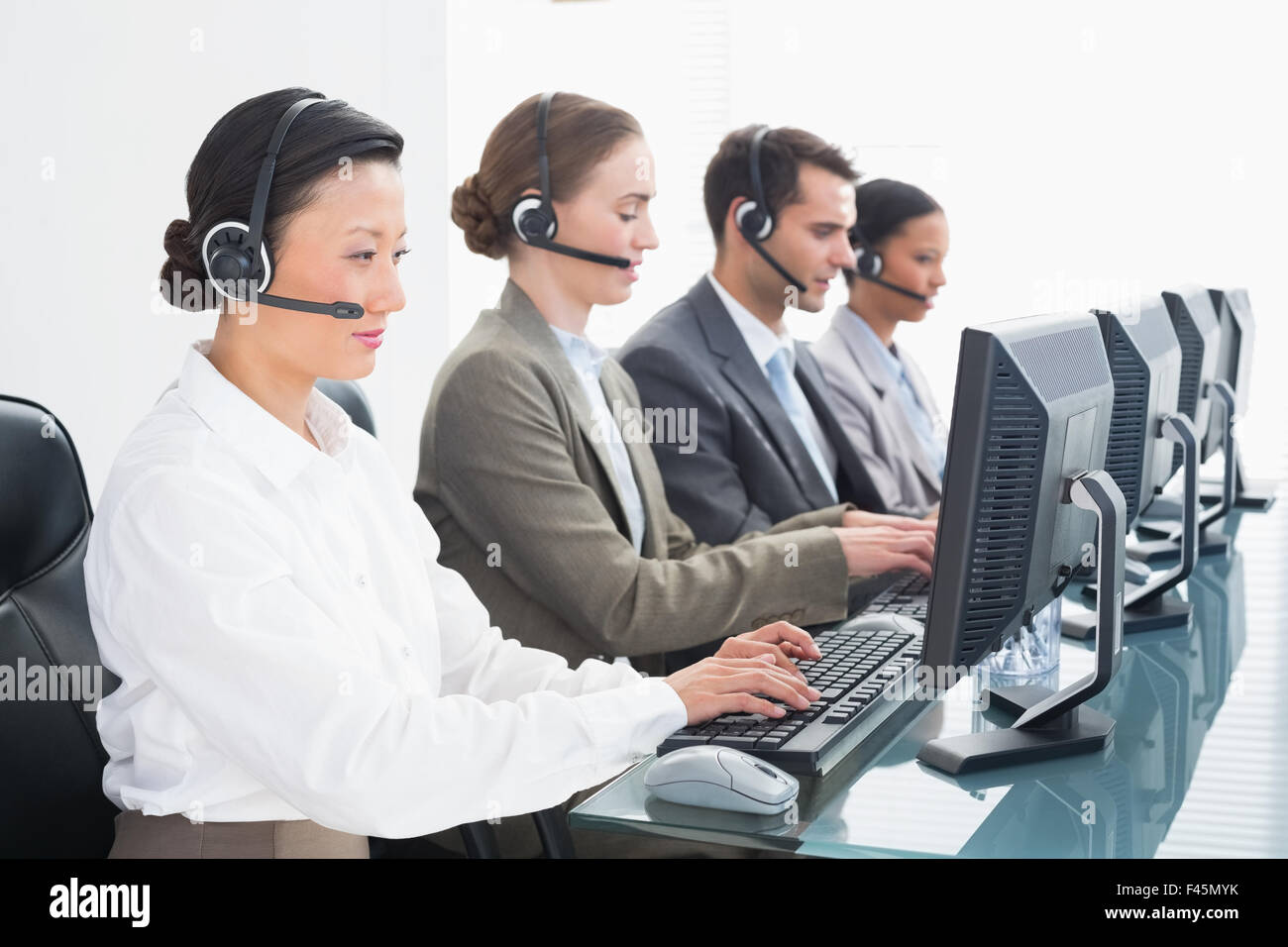 Business people with headsets using computers Stock Photo - Alamy