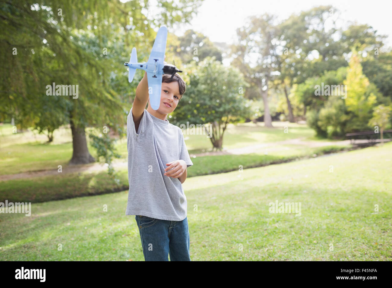 Boy playing with a toy plane at park Stock Photo - Alamy