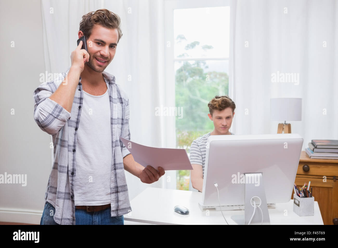 Man having phone call while his boyfriend working on computer Stock ...