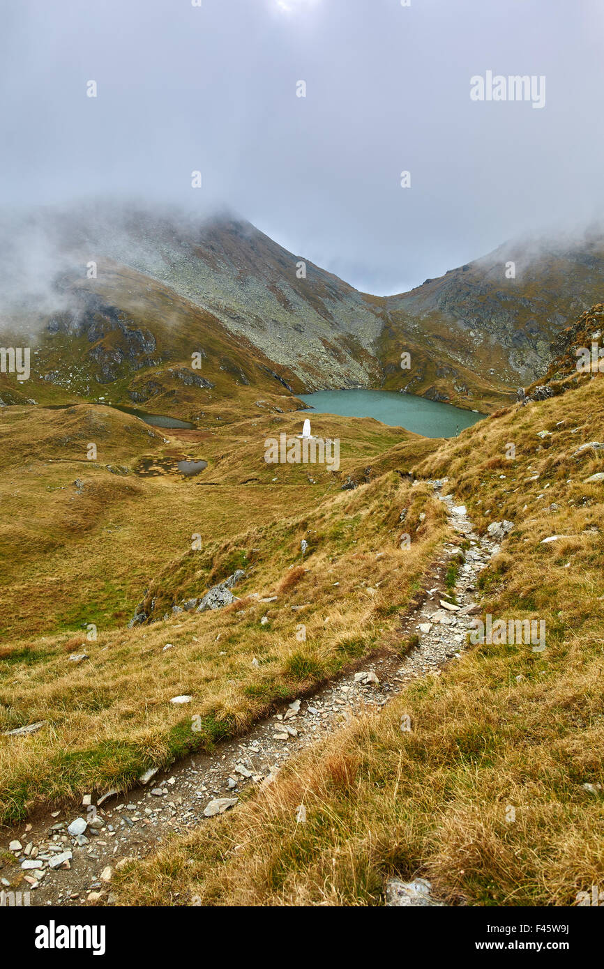 Landscape with a glacial lake in the mist between mountains Stock Photo ...