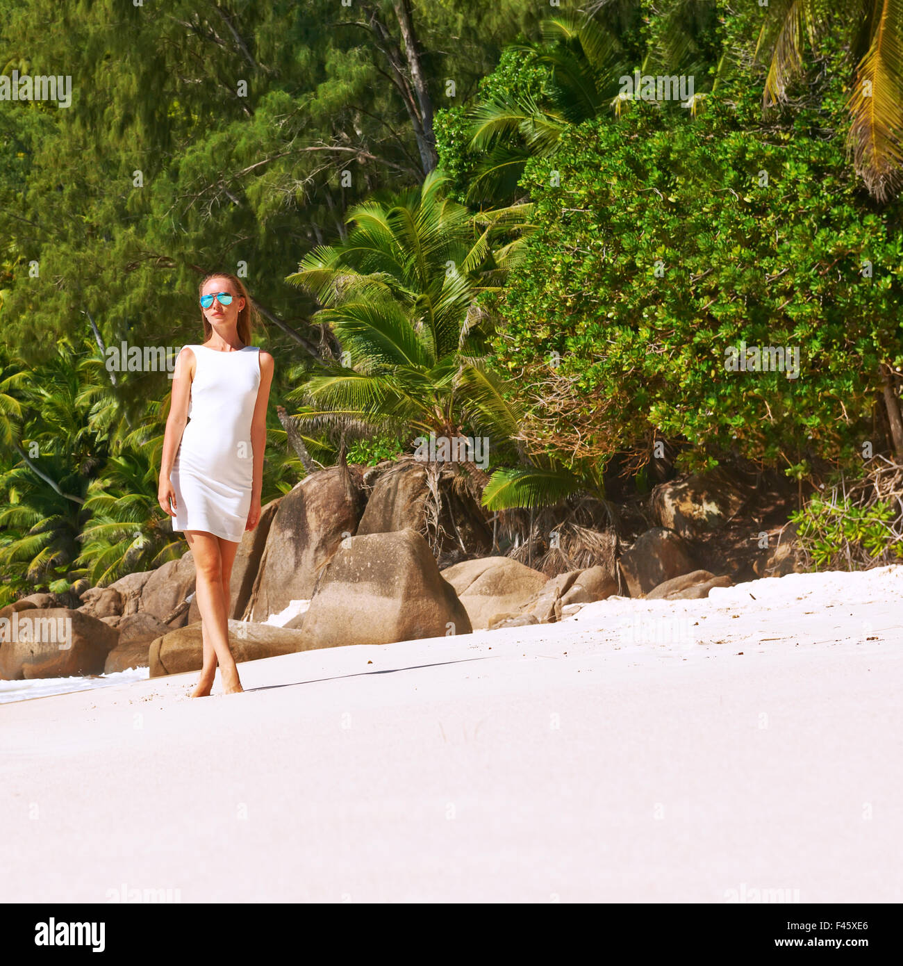 Woman wearing dress on beach at Seychelles Stock Photo - Alamy