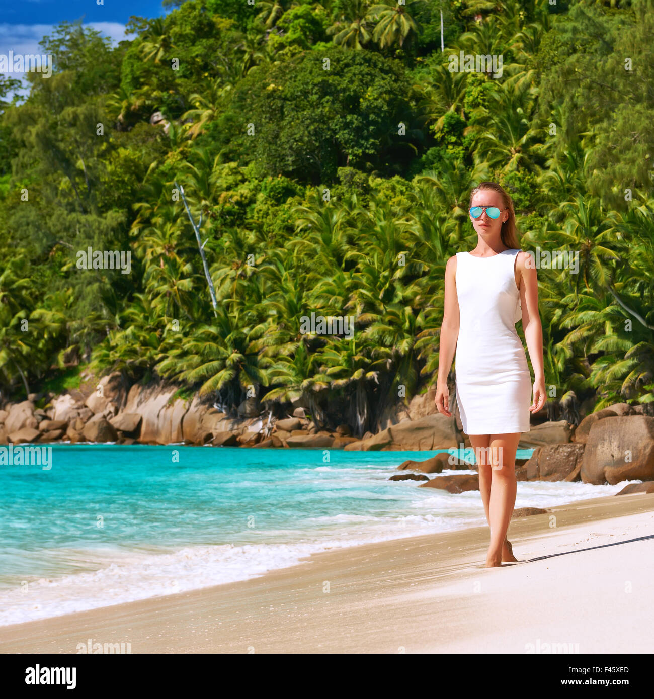 Woman wearing dress on beach at Seychelles Stock Photo - Alamy